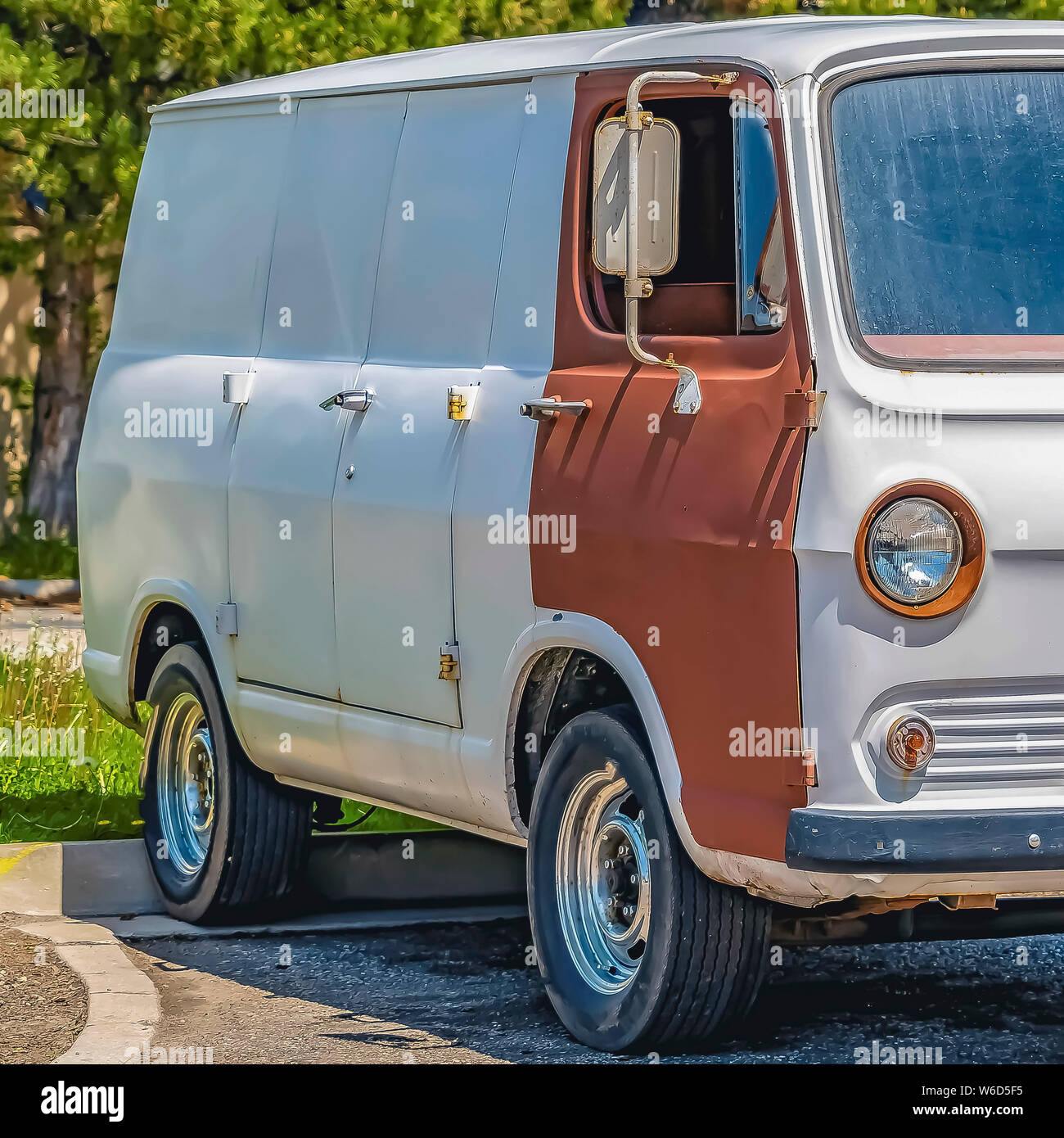 Square frame Front view of an old white van with brown door parked on ...