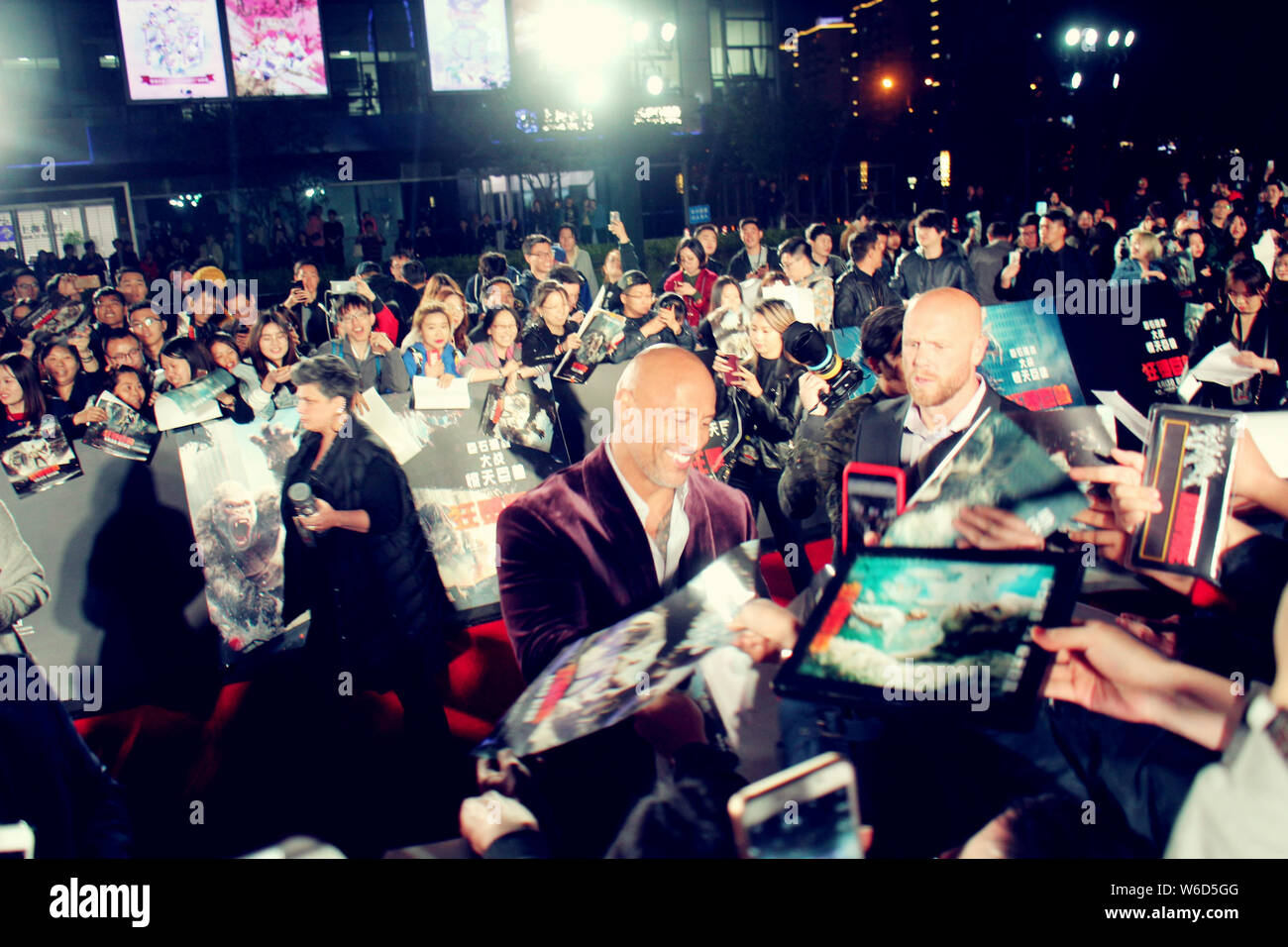 American actor Dwayne Johnson signs autographs for fans as he arrives ...