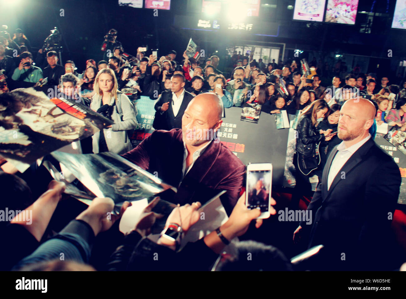 American actor Dwayne Johnson signs autographs for fans as he arrives ...