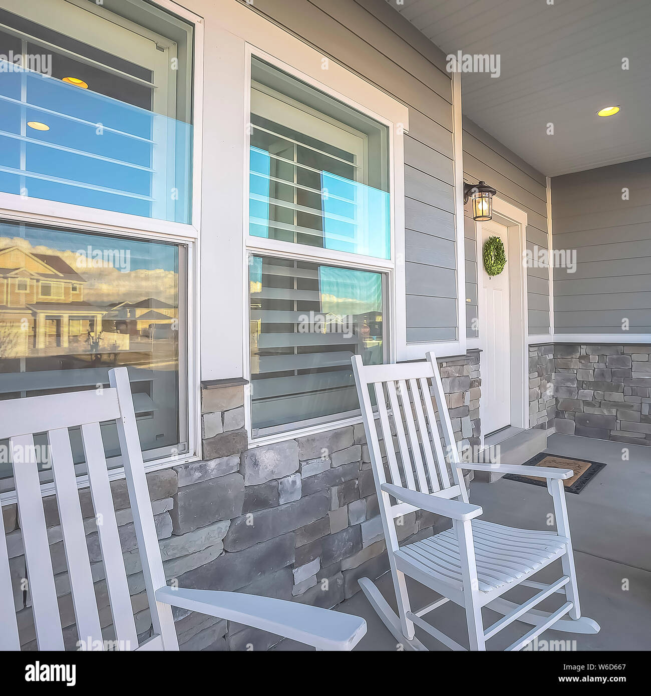 Square Porch with rocking chairs and door with wreath viewed at the ...