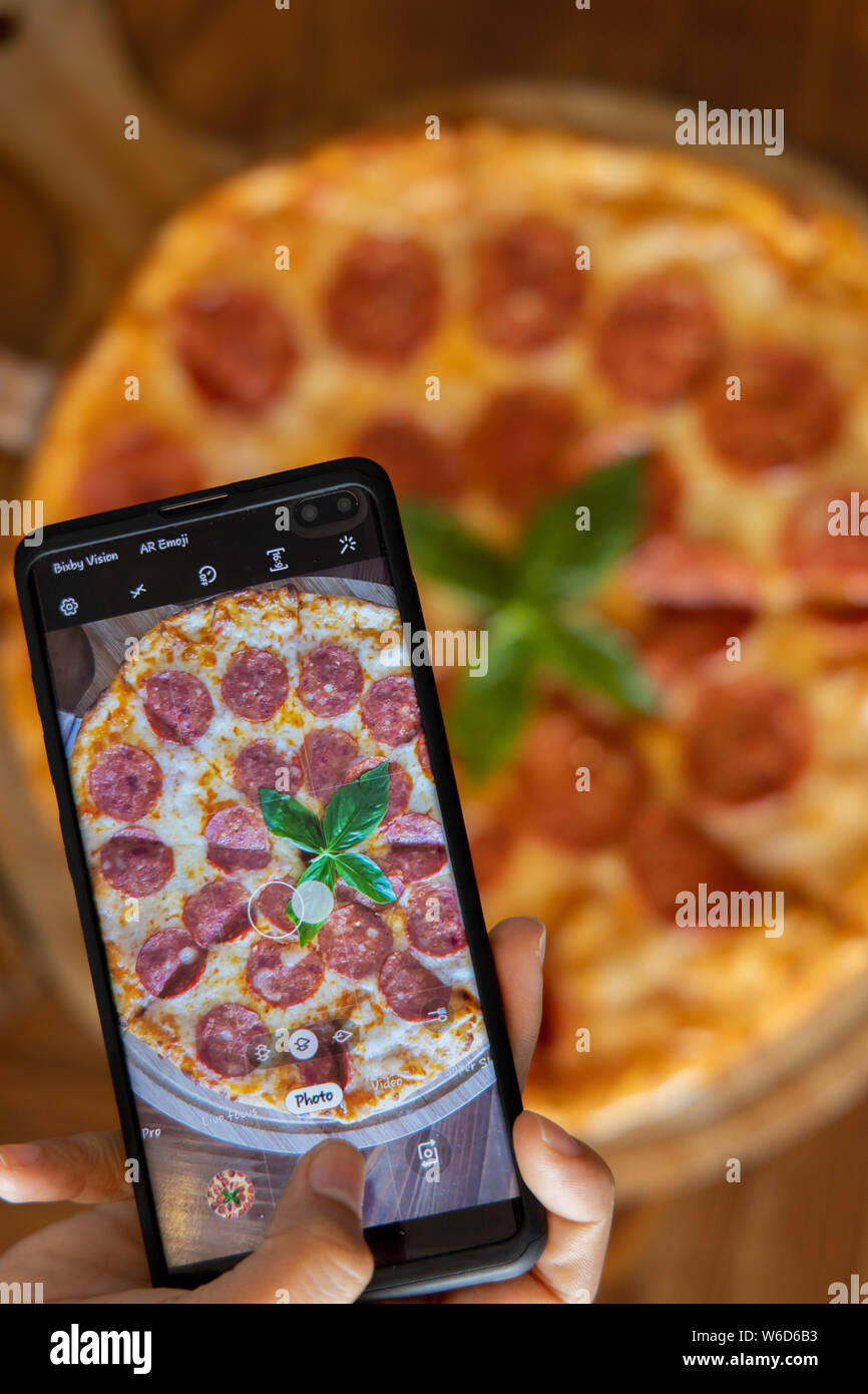 Pepperoni pizza with mobile phone, Philippines Stock Photo - Alamy