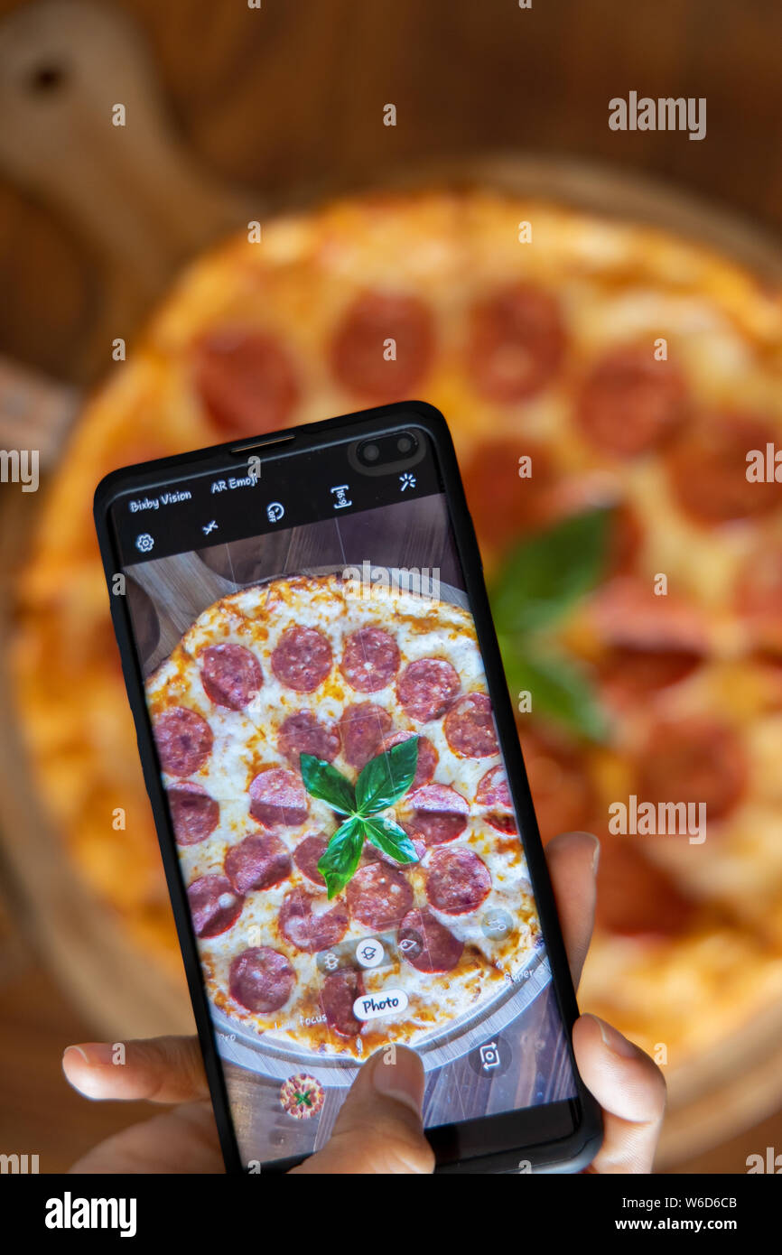 Pepperoni pizza with mobile phone, Philippines Stock Photo - Alamy