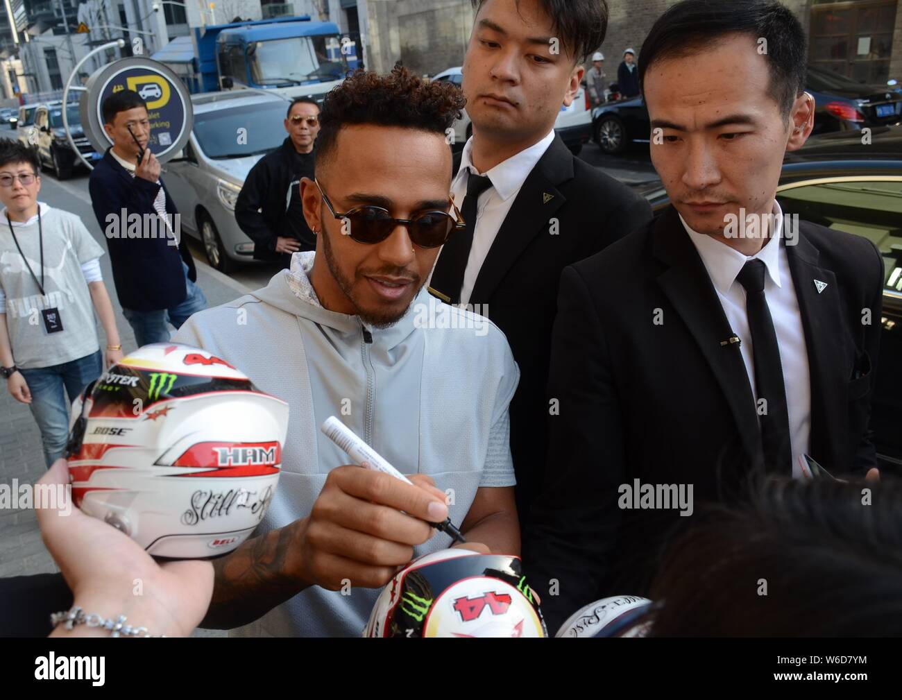 British F1 driver Lewis Hamilton of Mercedes signs autographs for fans ...