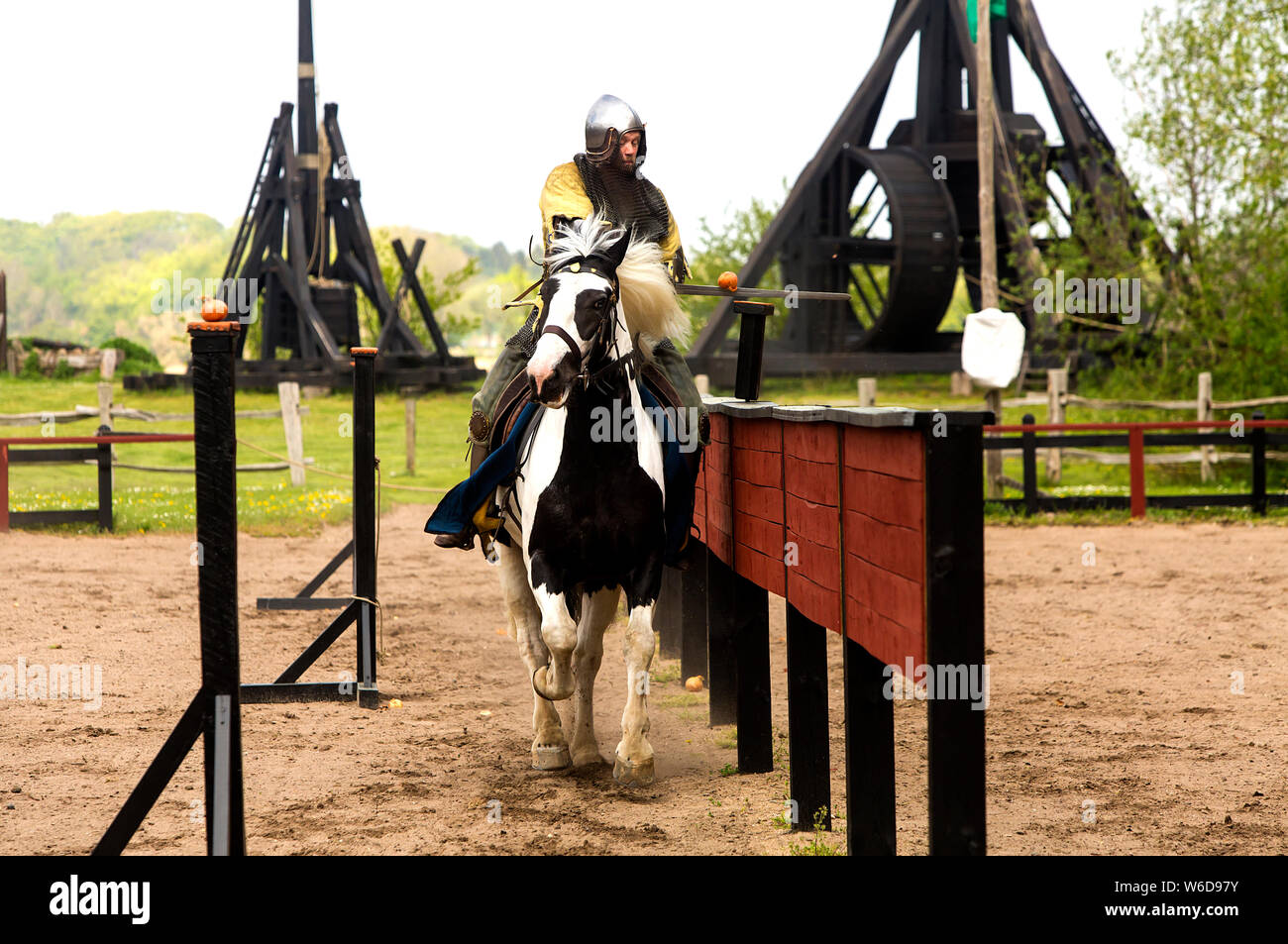 A knight in armour jousting with lance at the outdoor Medieval Centre ...