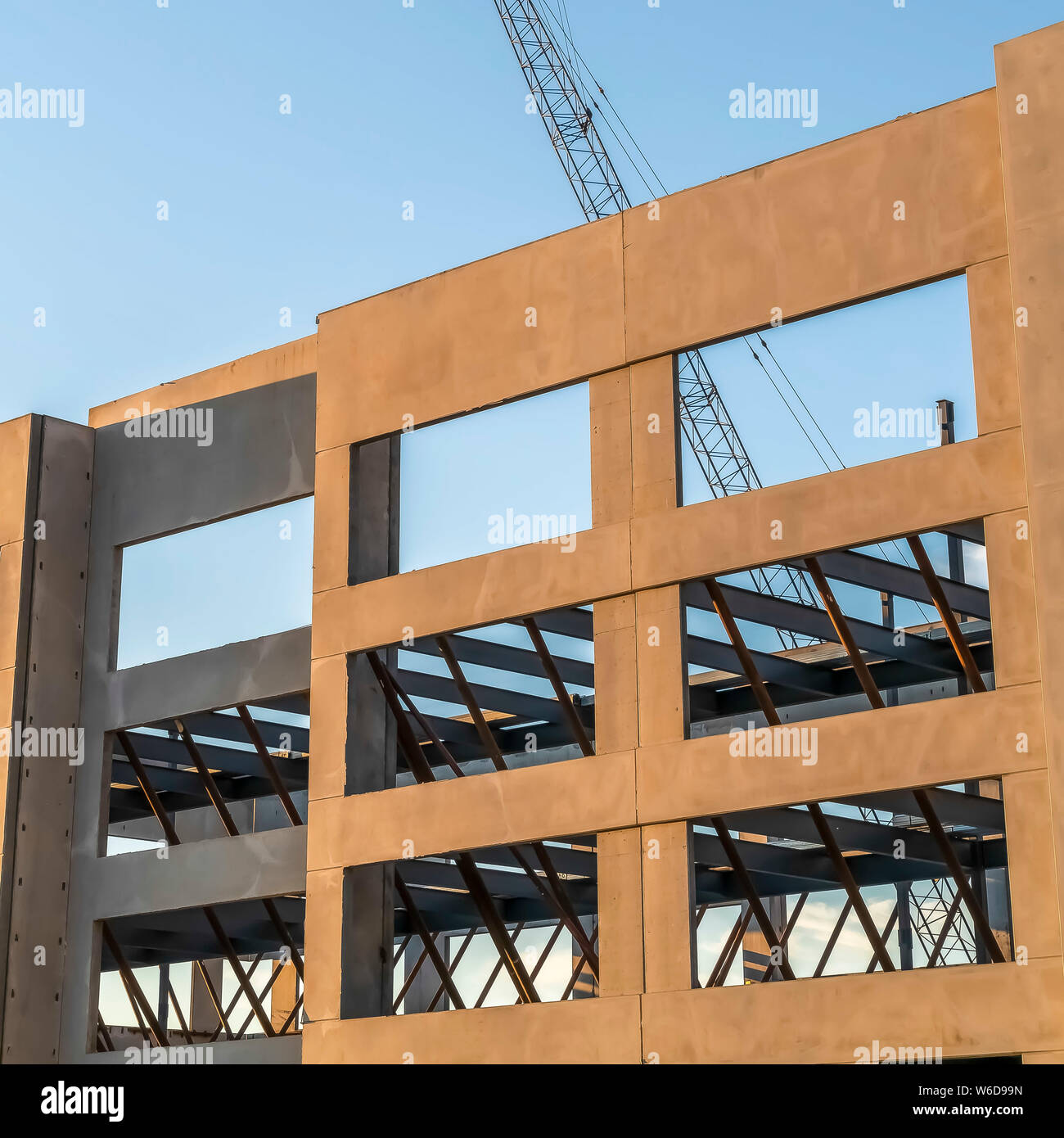 Square frame Building under construction with metal crane and blue sky ...