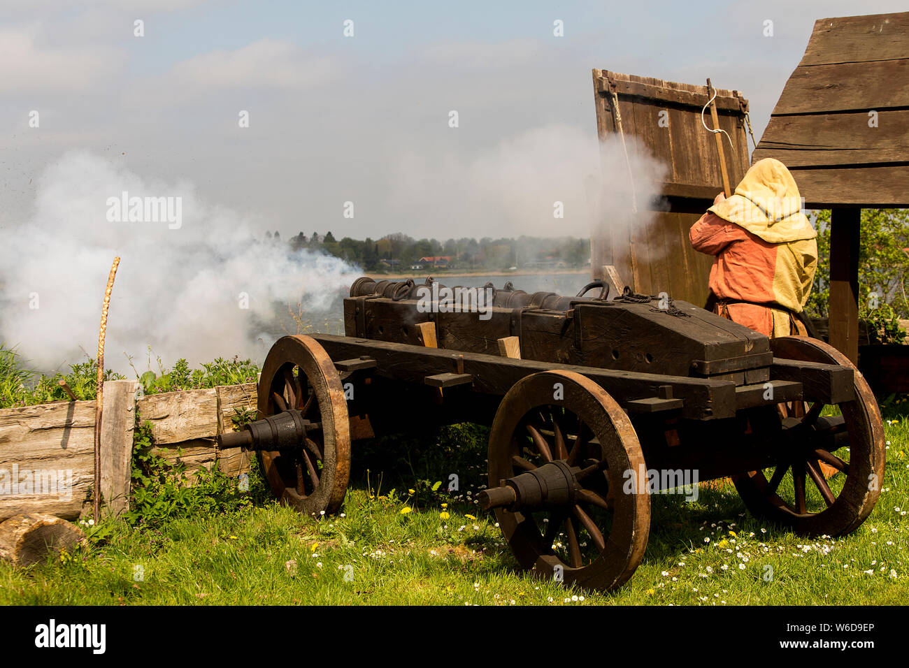 An artillerist is firing off a medieval cannon at the outdoor Medieval ...