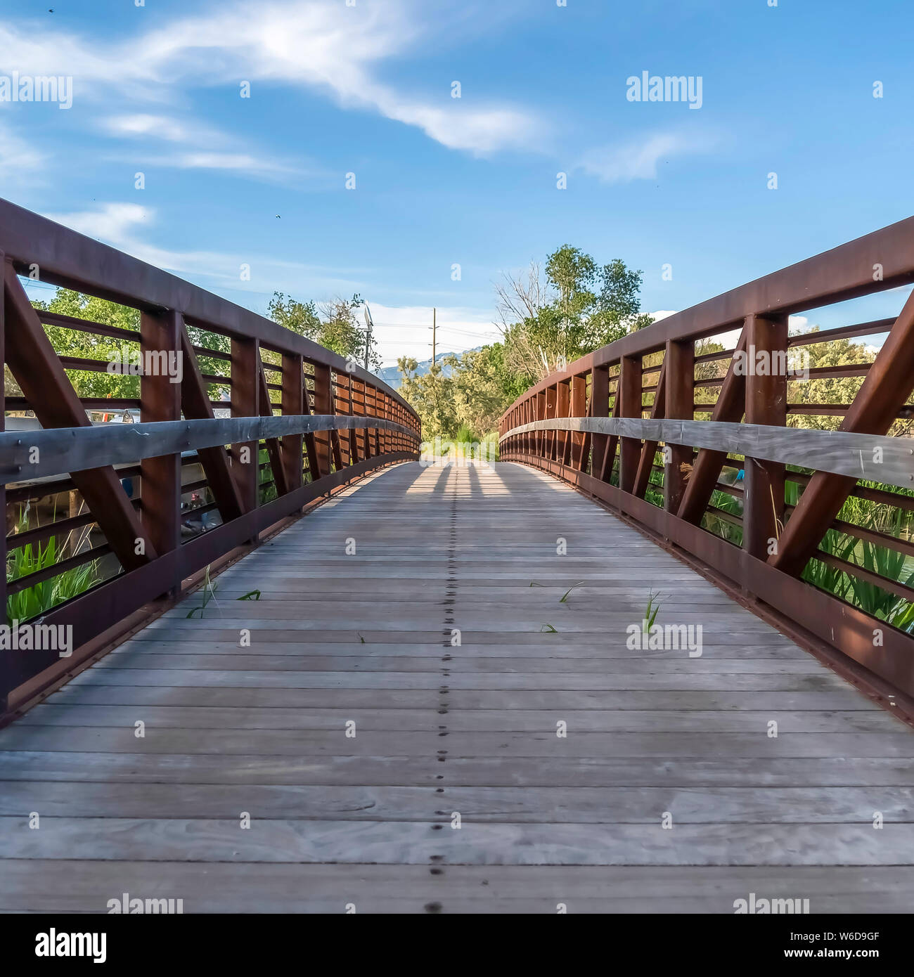 Square frame Close up of bridge overlooking trees mountain and blue sky ...
