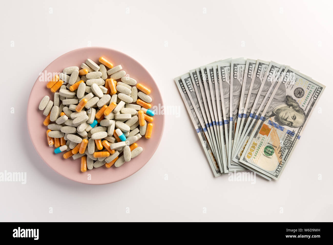 A plate with pills and US dollar bank notes isolated on white ...