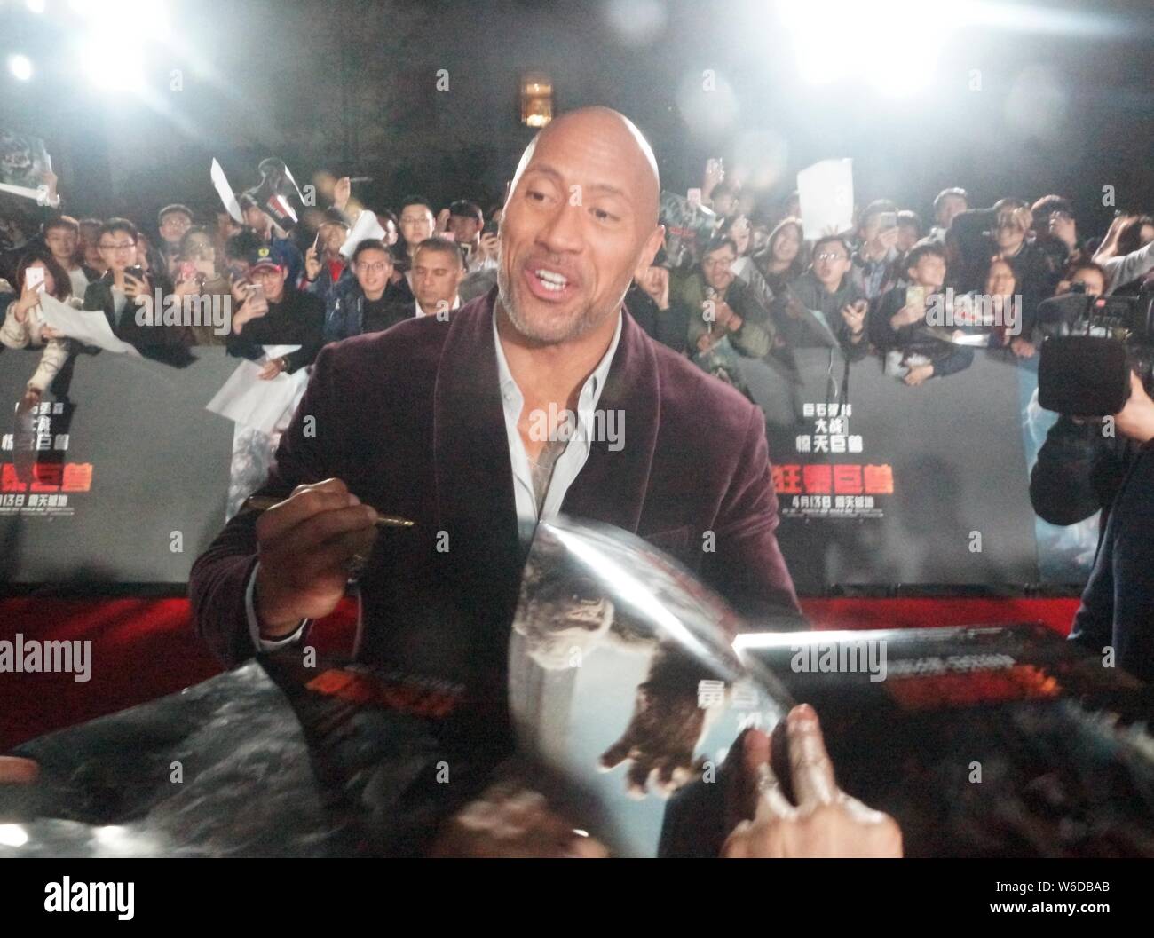 American actor Dwayne Johnson signs autographs for fans as he arrives ...