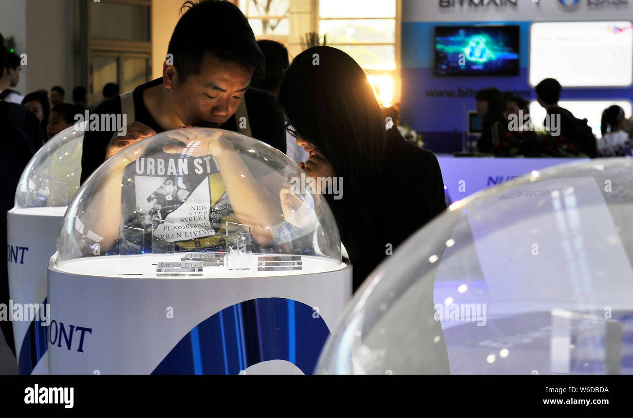 Visitors look at chips developed by Nufront during the first Digital ...