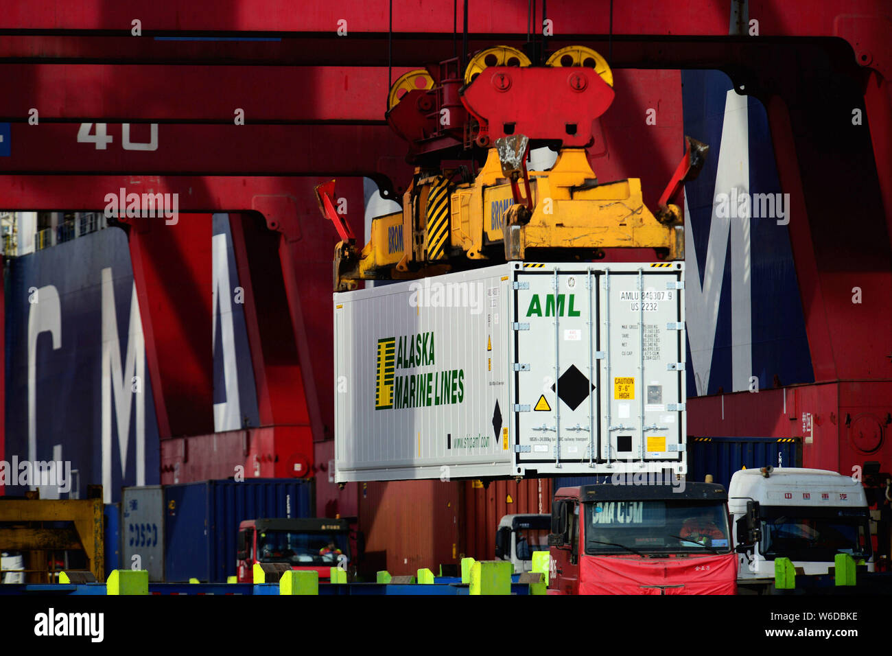 A crane vehicle lifts a container to be shipped abroad from a truck on ...