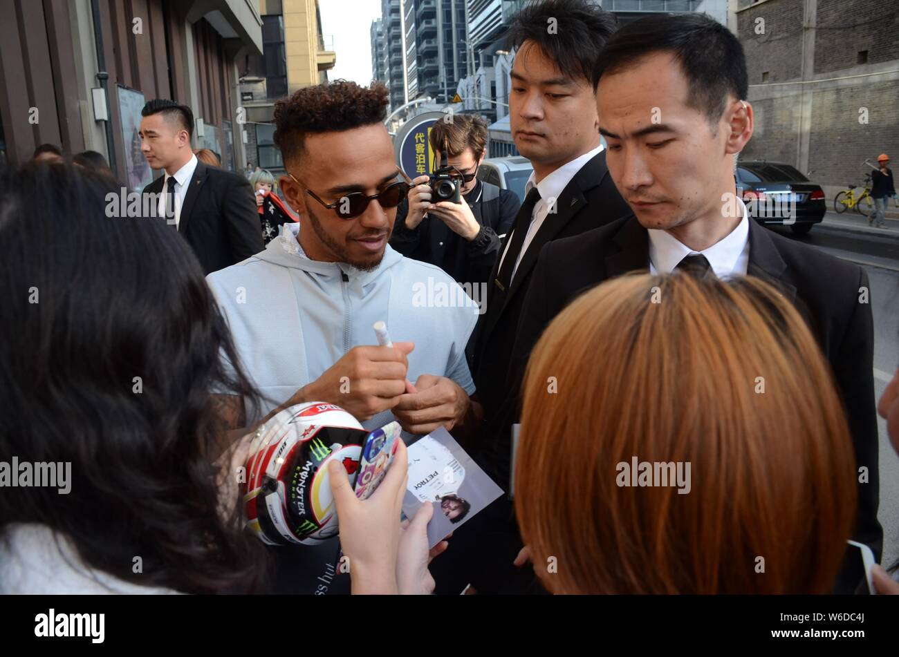 British F1 driver Lewis Hamilton of Mercedes signs autographs for fans ...