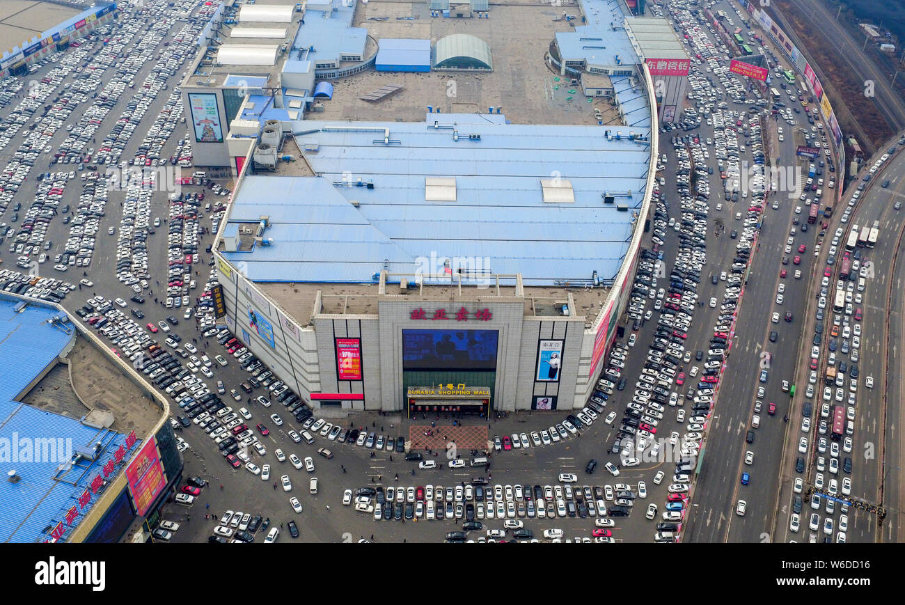 Aerial view of masses of vehicles at a parking lot of a shopping mall ...