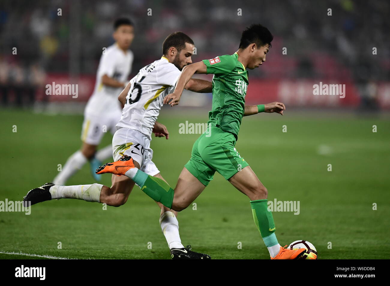 Spanish soccer player Mario Suarez, left, of Guizhou Hengfeng challenges Hu Yanqiang Beijing ...