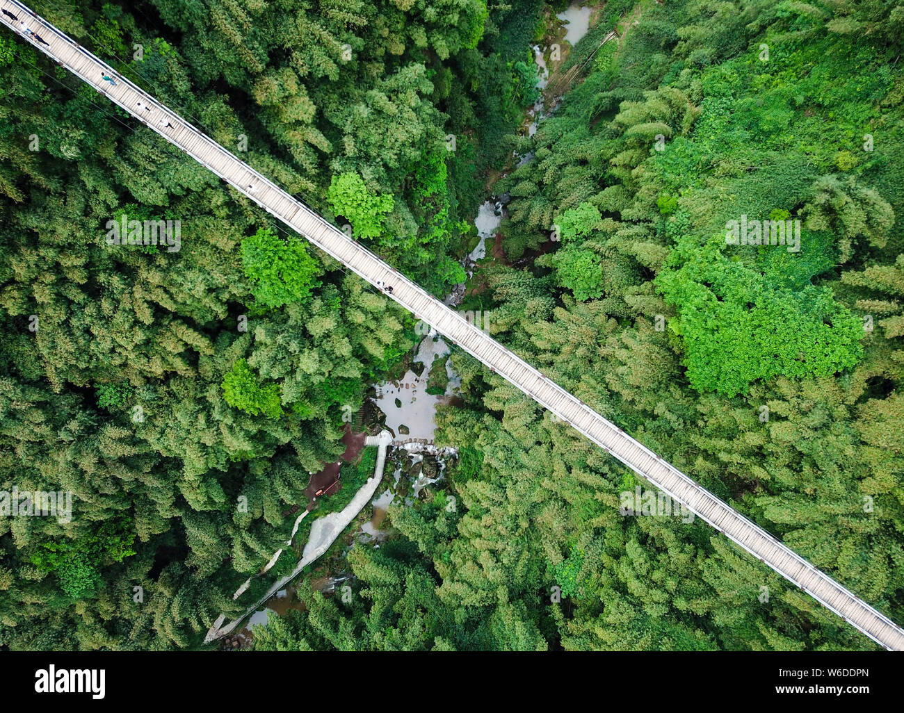 Tourists walk on the newly-built glass walkway along the edge of a ...