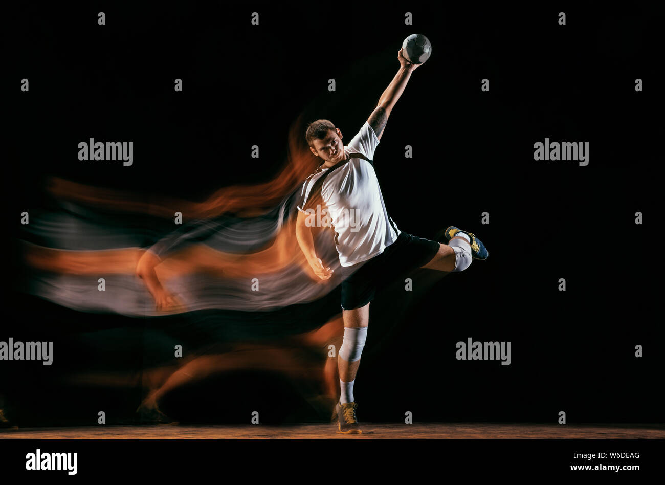 Caucasian young handball player in action and motion in mixed lights ...