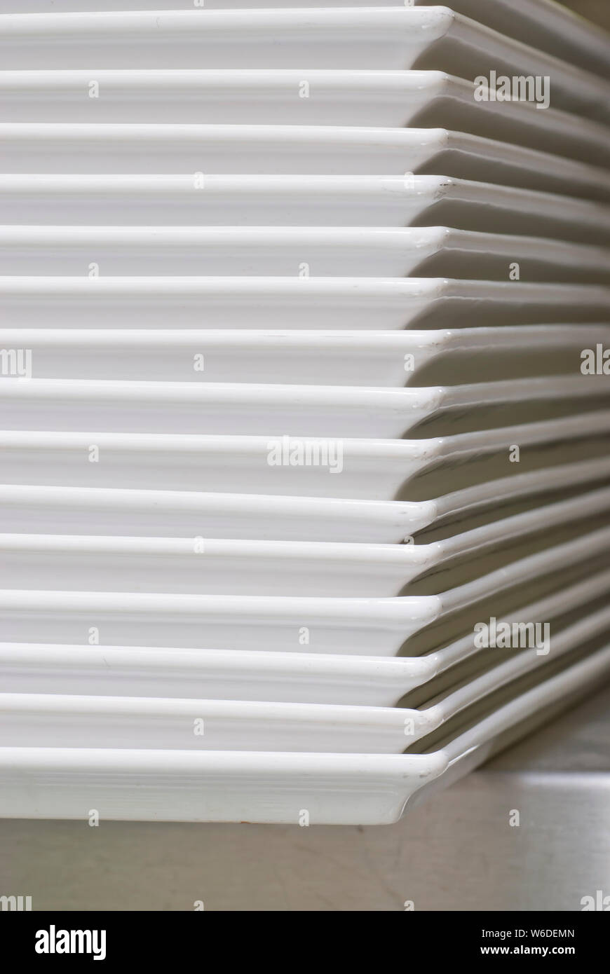 Stack of white square plates Stock Photo - Alamy
