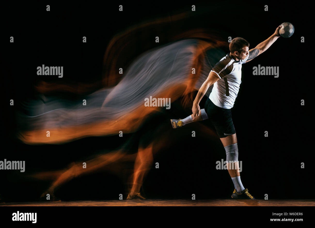 Caucasian young handball player in action and motion in mixed lights ...