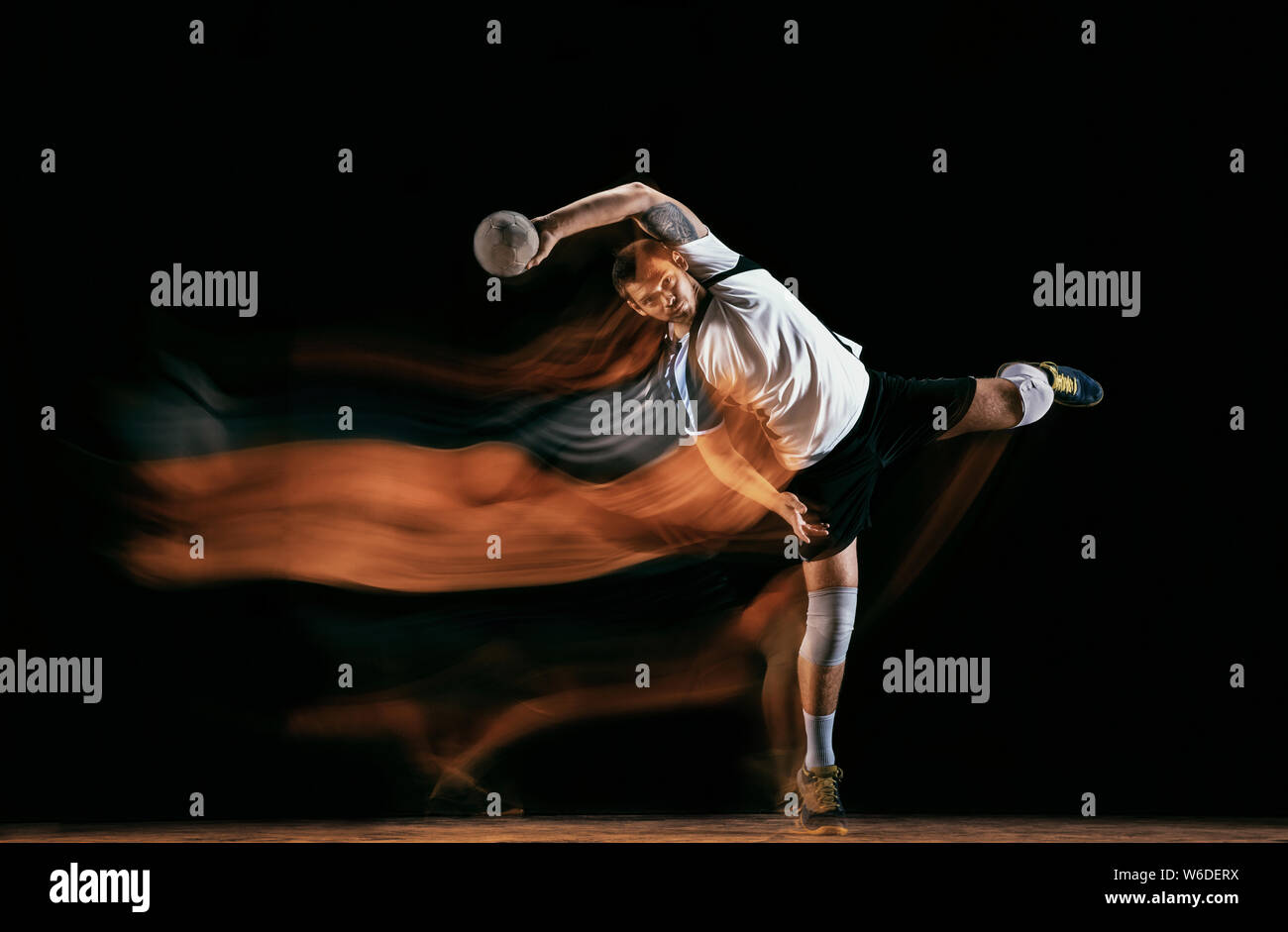 Caucasian young handball player in action and motion in mixed lights ...