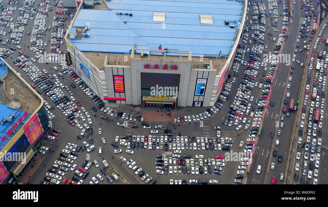 Aerial view of masses of vehicles at a parking lot of a shopping mall ...