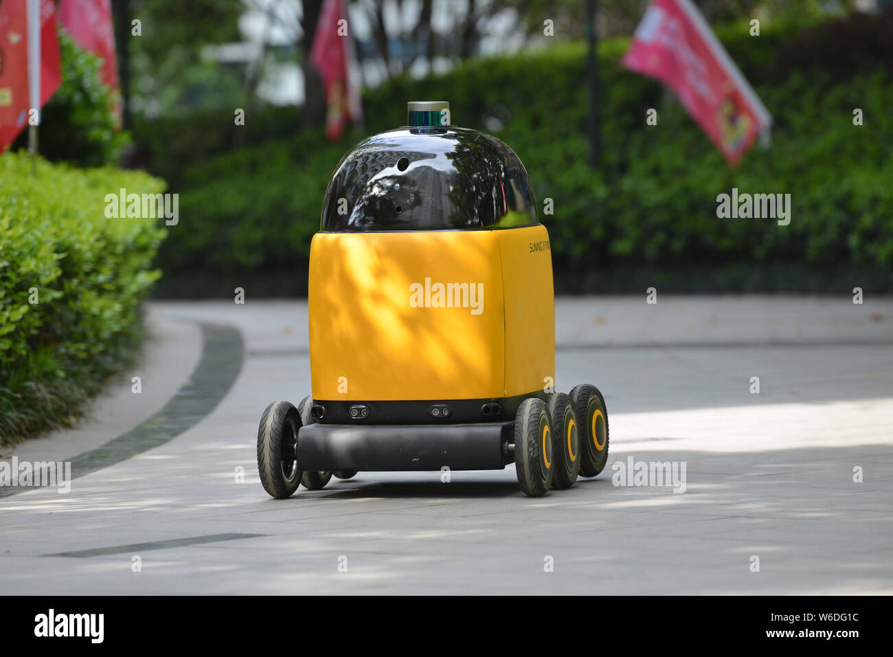 An unmanned delivery car of Suning Logistics is on its way to deliver ...