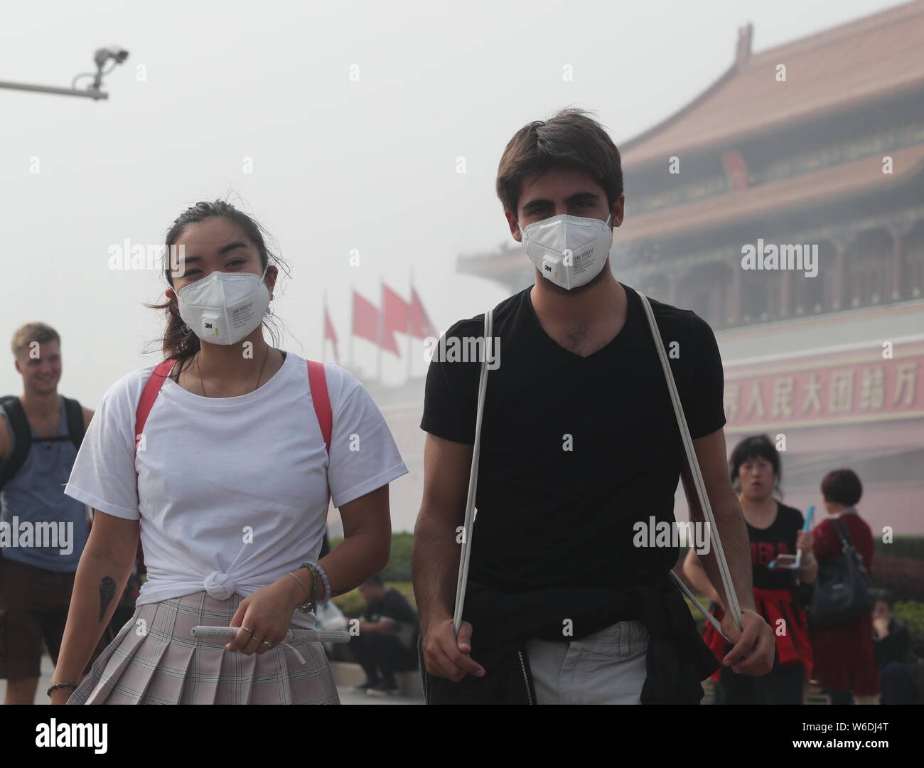 Tourists wearing face masks against air pollution visit the Tian'anmen ...