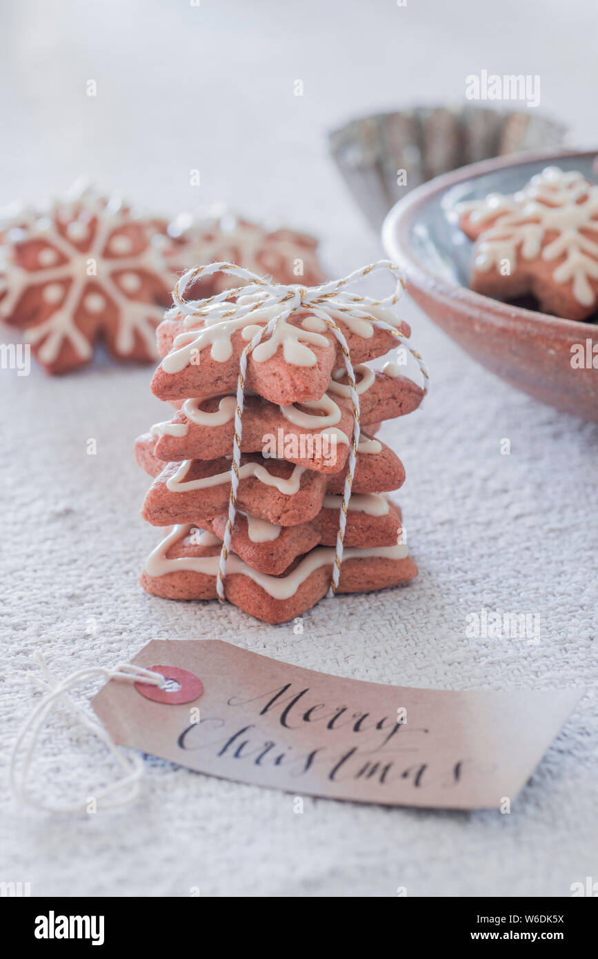 Stack of homemade biscuits with snowflake icing, tied with string and ...