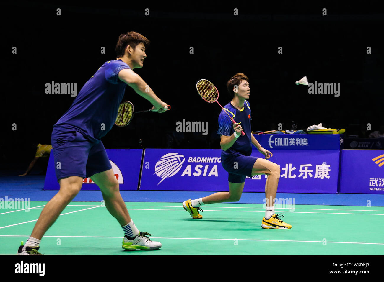Li Junhui, back, of China returns a shot as he and Liu Yuchen compete ...