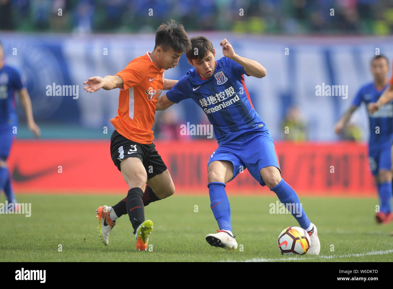 Paraguayan soccer player Oscar Romero, right, of Shanghai Greenland Shenhua kicks the ball to ...