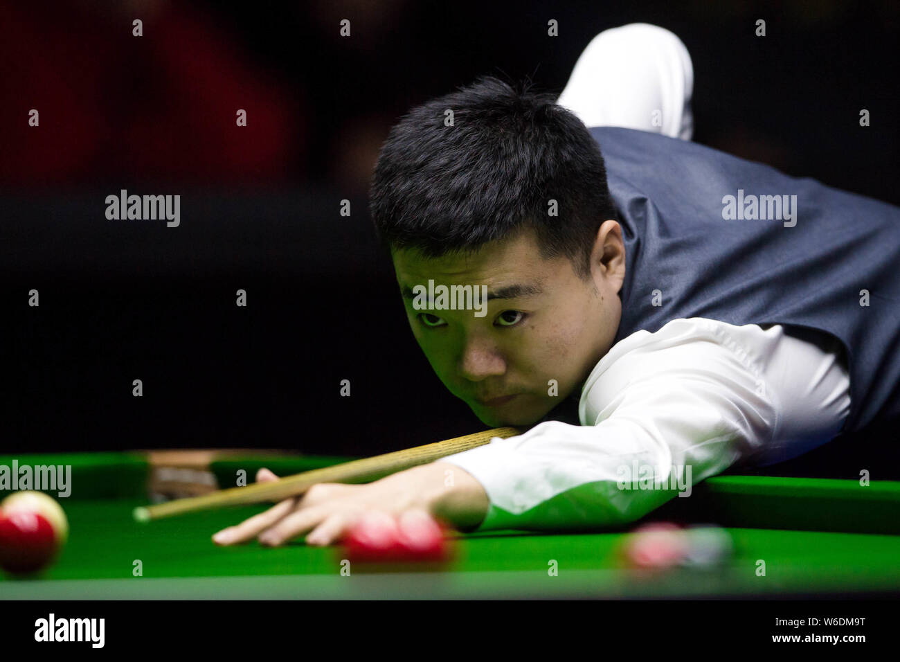 Ding Junhui of China plays a shot to Kyren Wilson of England in their third round match during ...