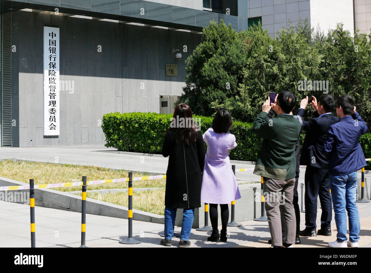 Visitors take photos of the headquarters of China Banking and Insurance ...