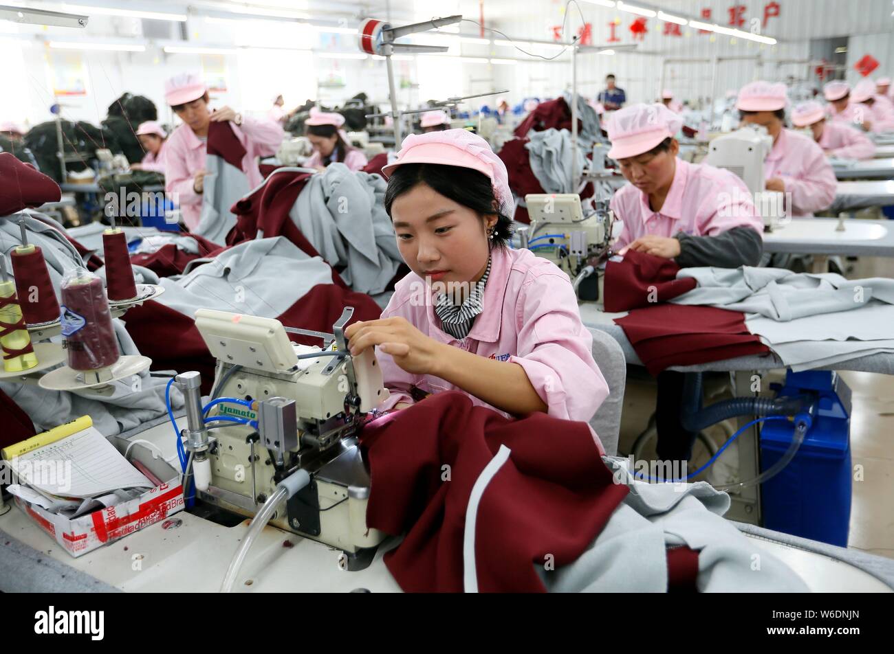 --FILE--A female Chinese worker sews clothes at a garment factory in Heza city, east China's ...