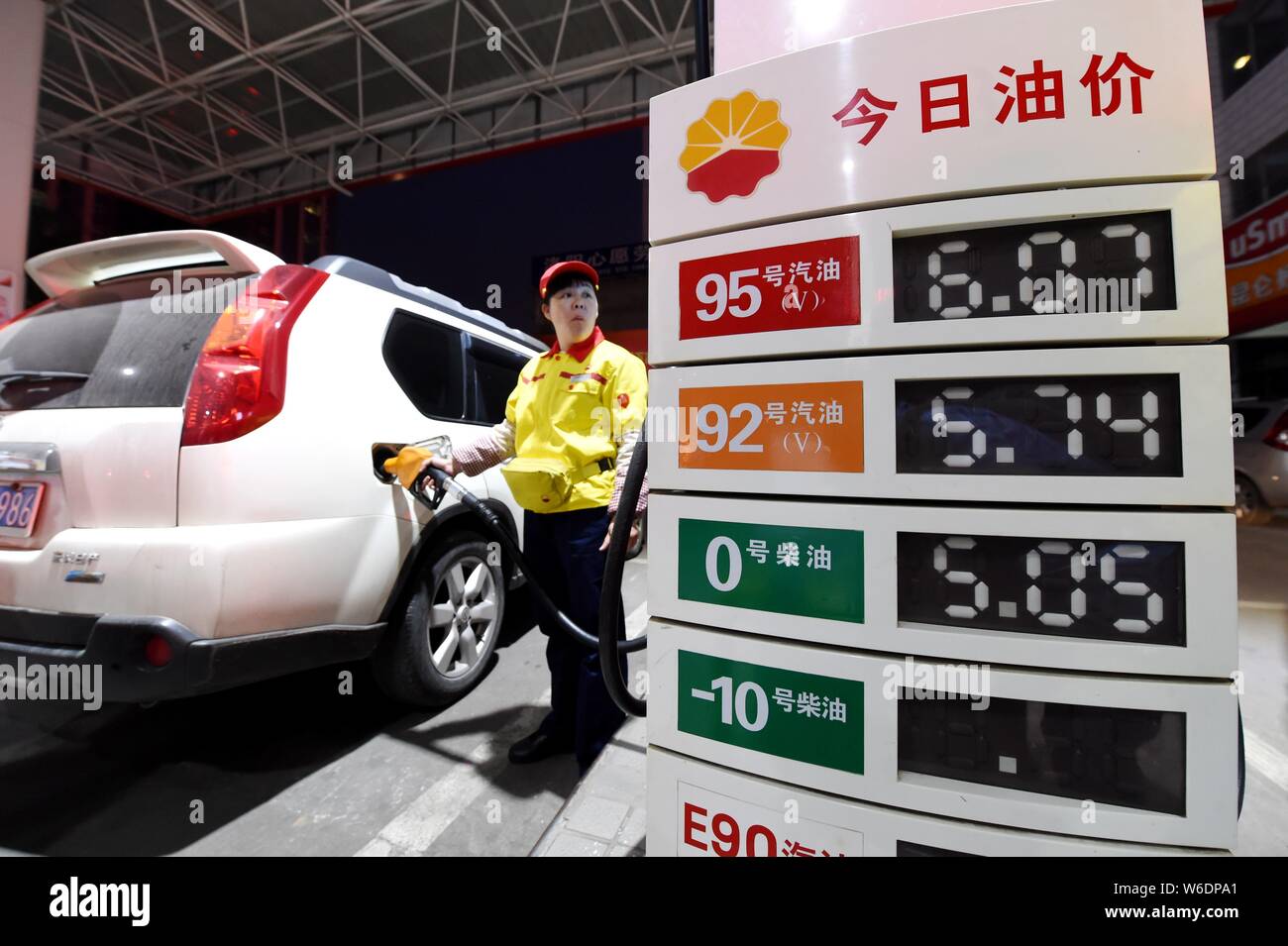 --FILE--A Chinese worker refuels a car at a gas station of CNPC (China ...