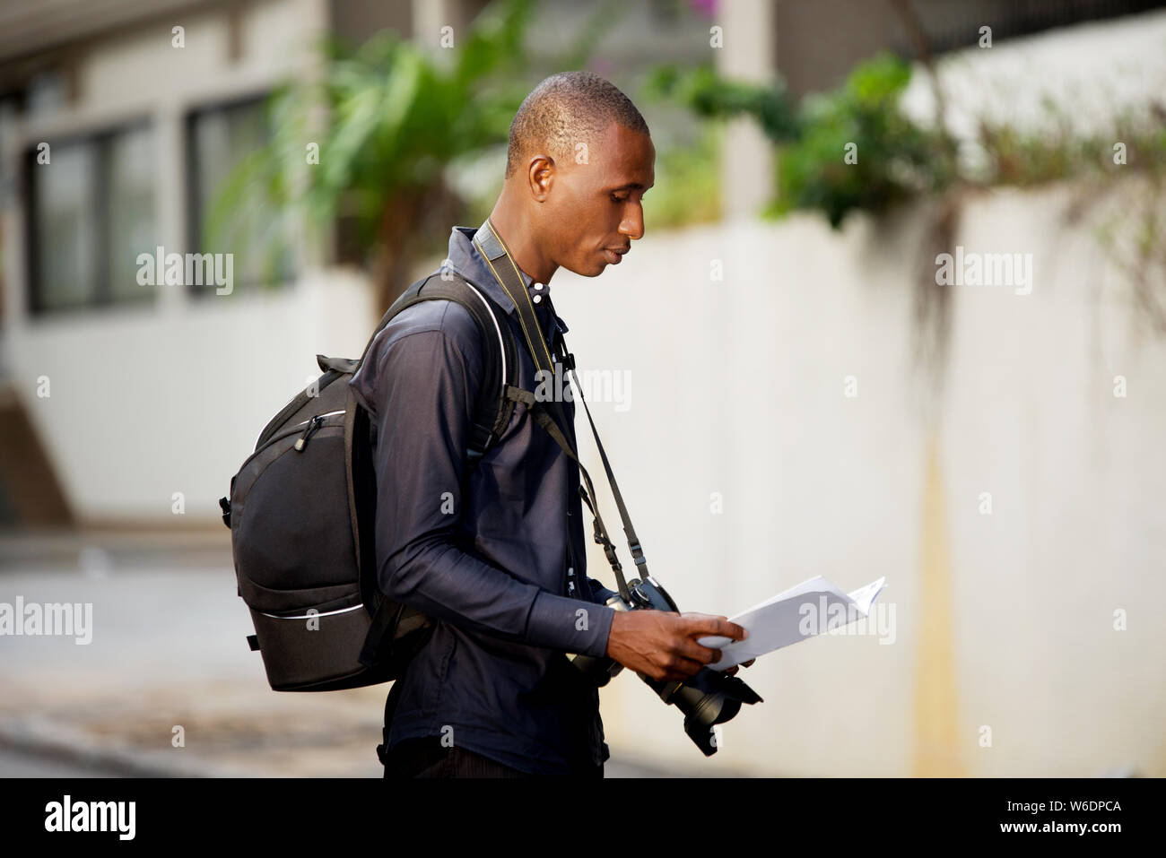 tourist man with map in hands explores the city in search of adventures ...
