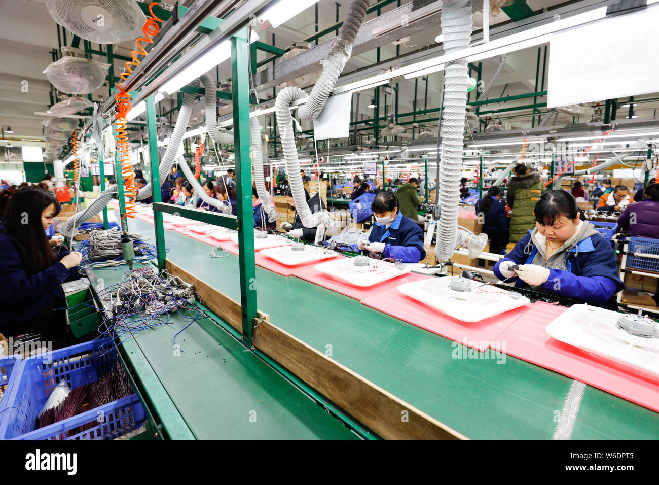Chinese workers assemble electric fans on the assembly line at a ...