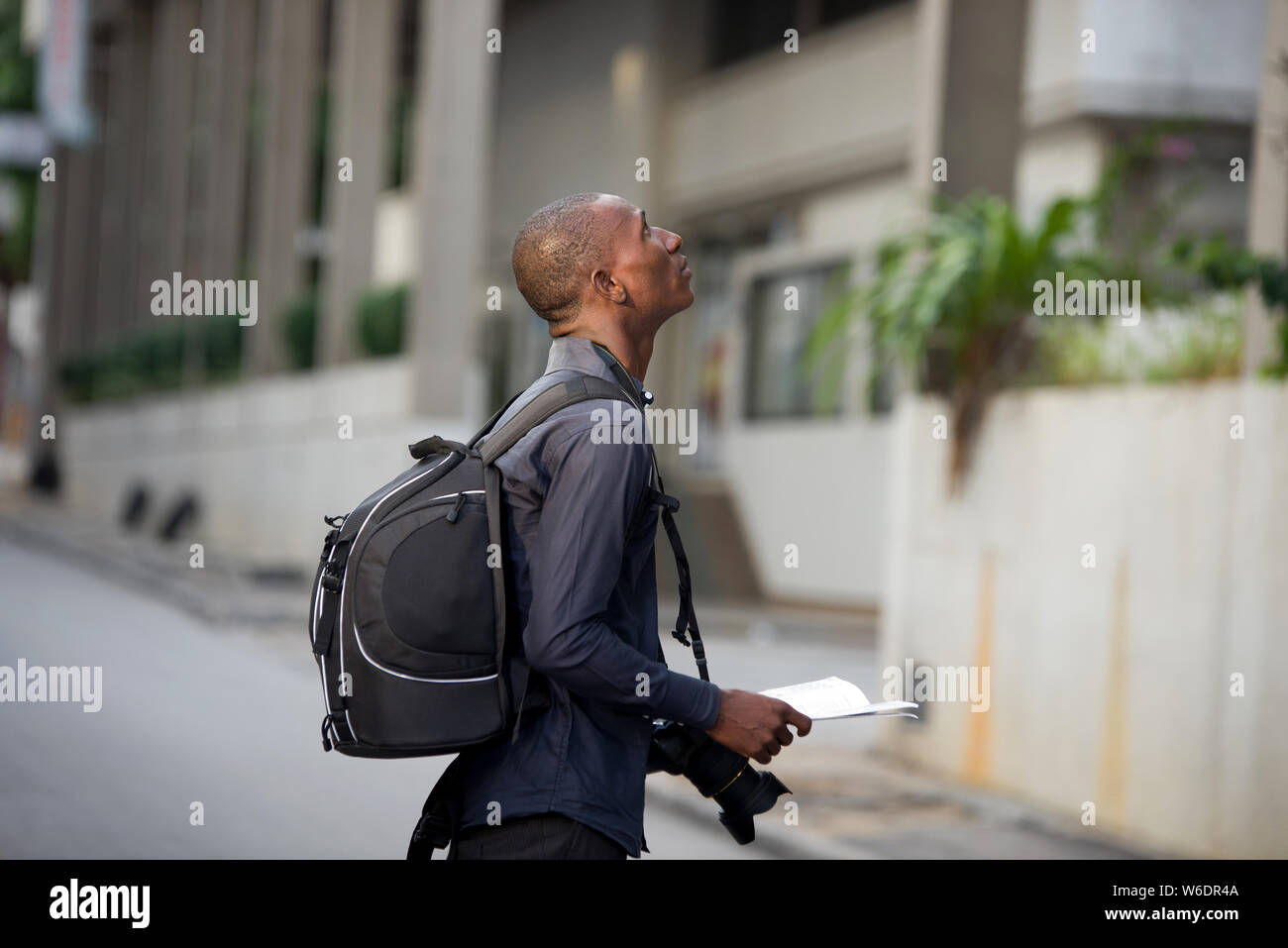 tourist man with map in hands explores the city in search of adventures ...