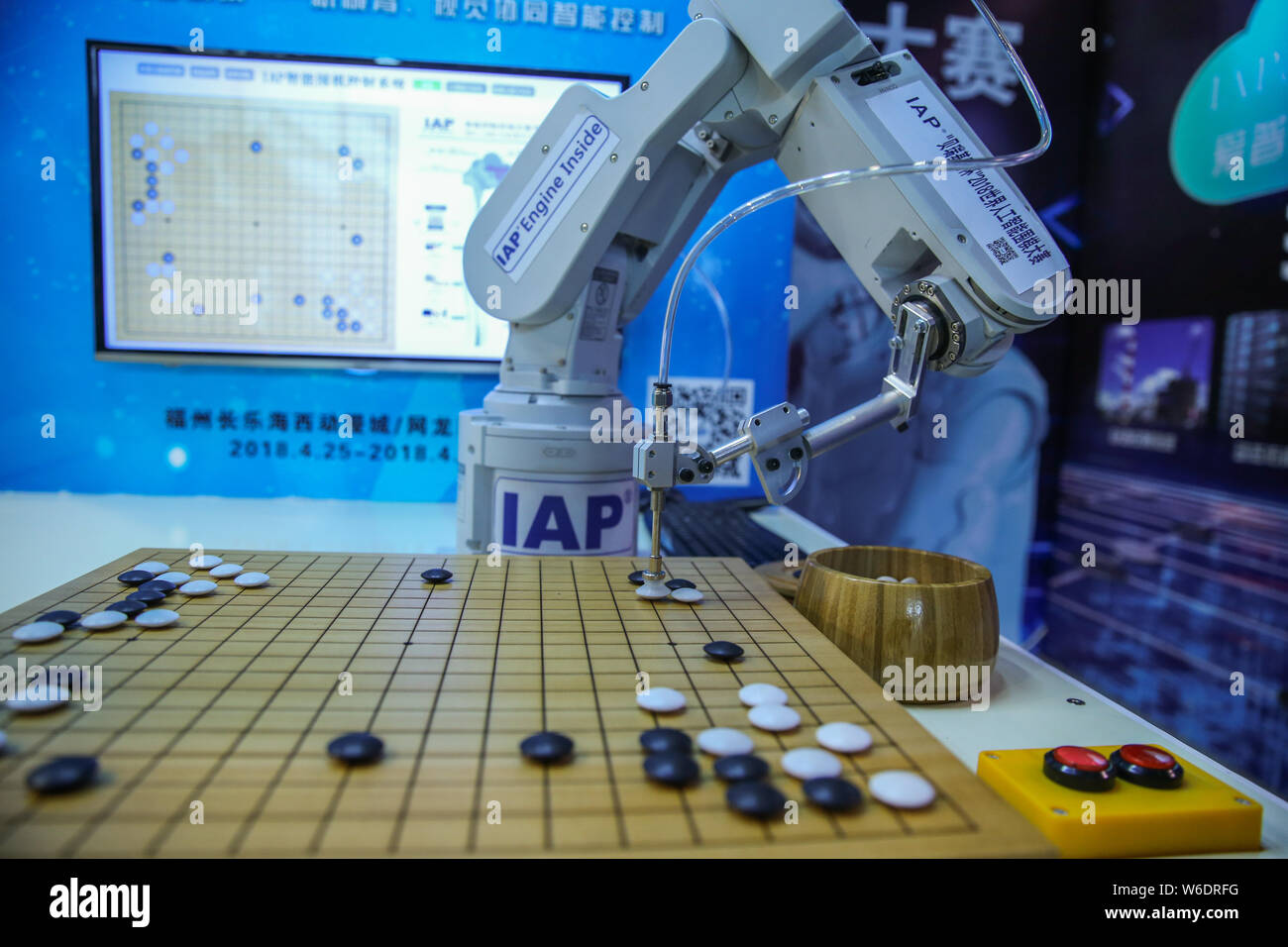 A robot arm operated by an AI program plays a Go game with Chinese Go ...