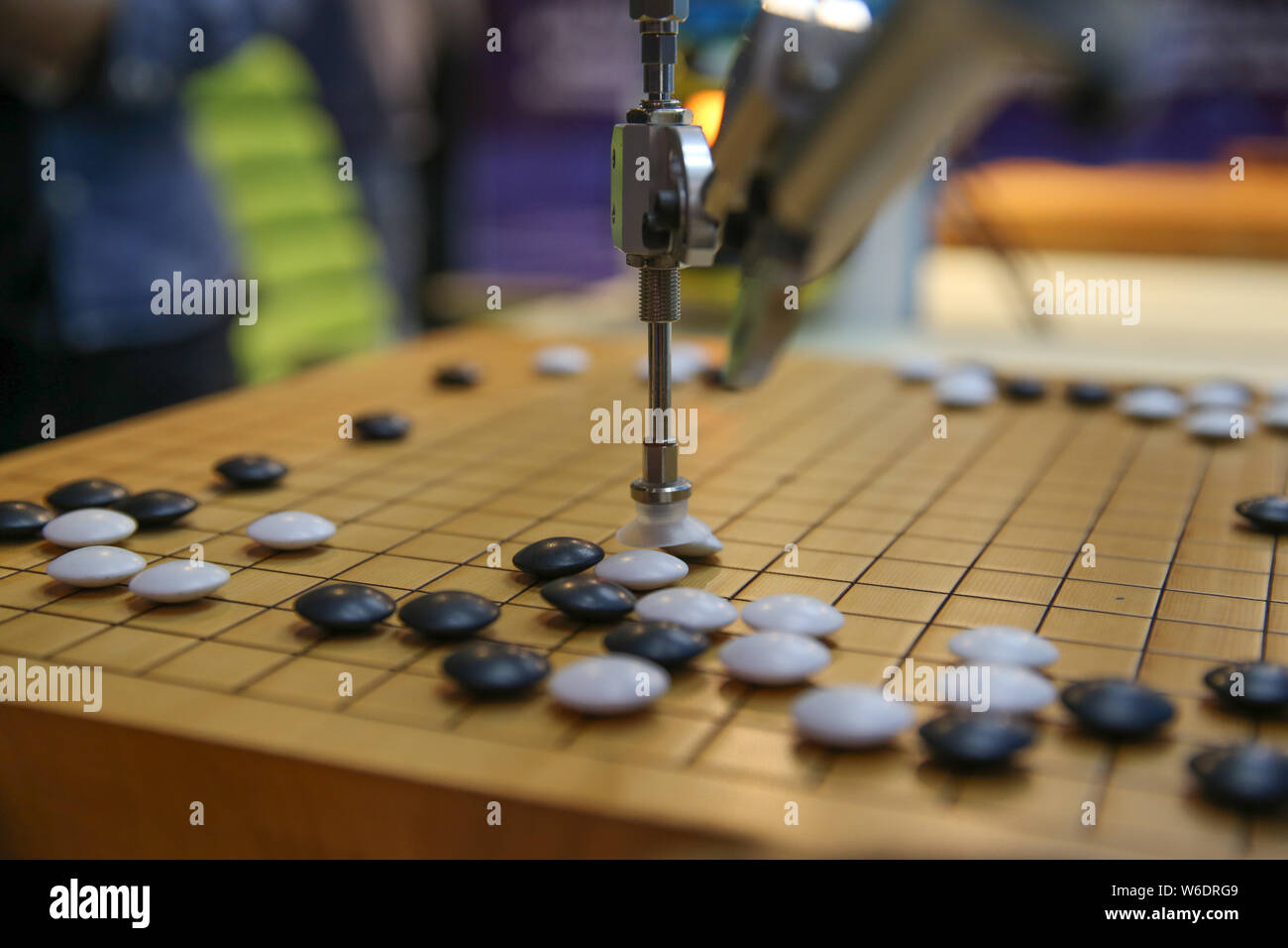 A robot arm operated by an AI program plays a Go game with Chinese Go ...