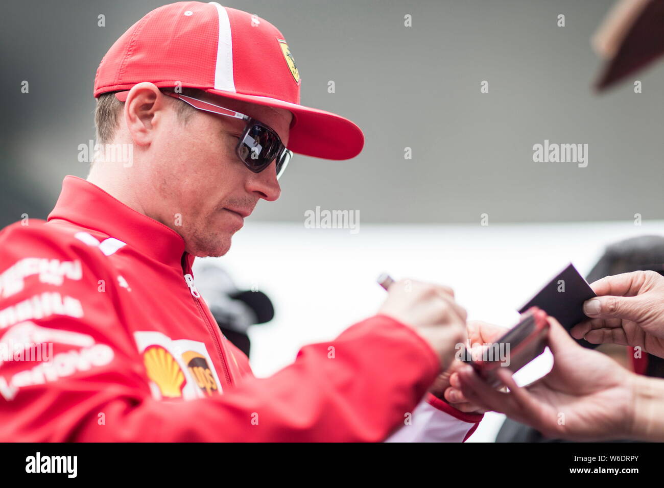 Finnish F1 driver Kimi Raikkonen of Ferrari signs autographs for fans ...