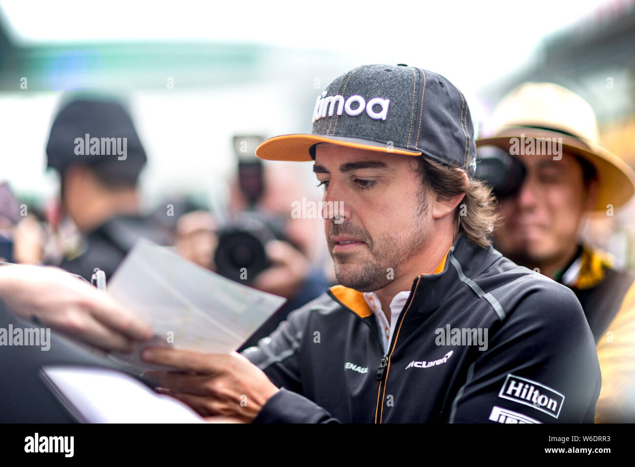 Spanish F1 driver Fernando Alonso of McLaren autographs for fans at the ...