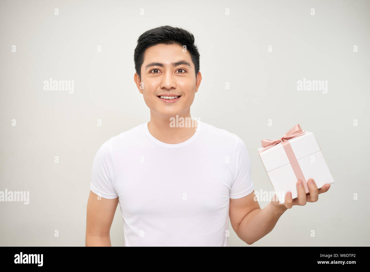 A man holding present box on white background Stock Photo - Alamy
