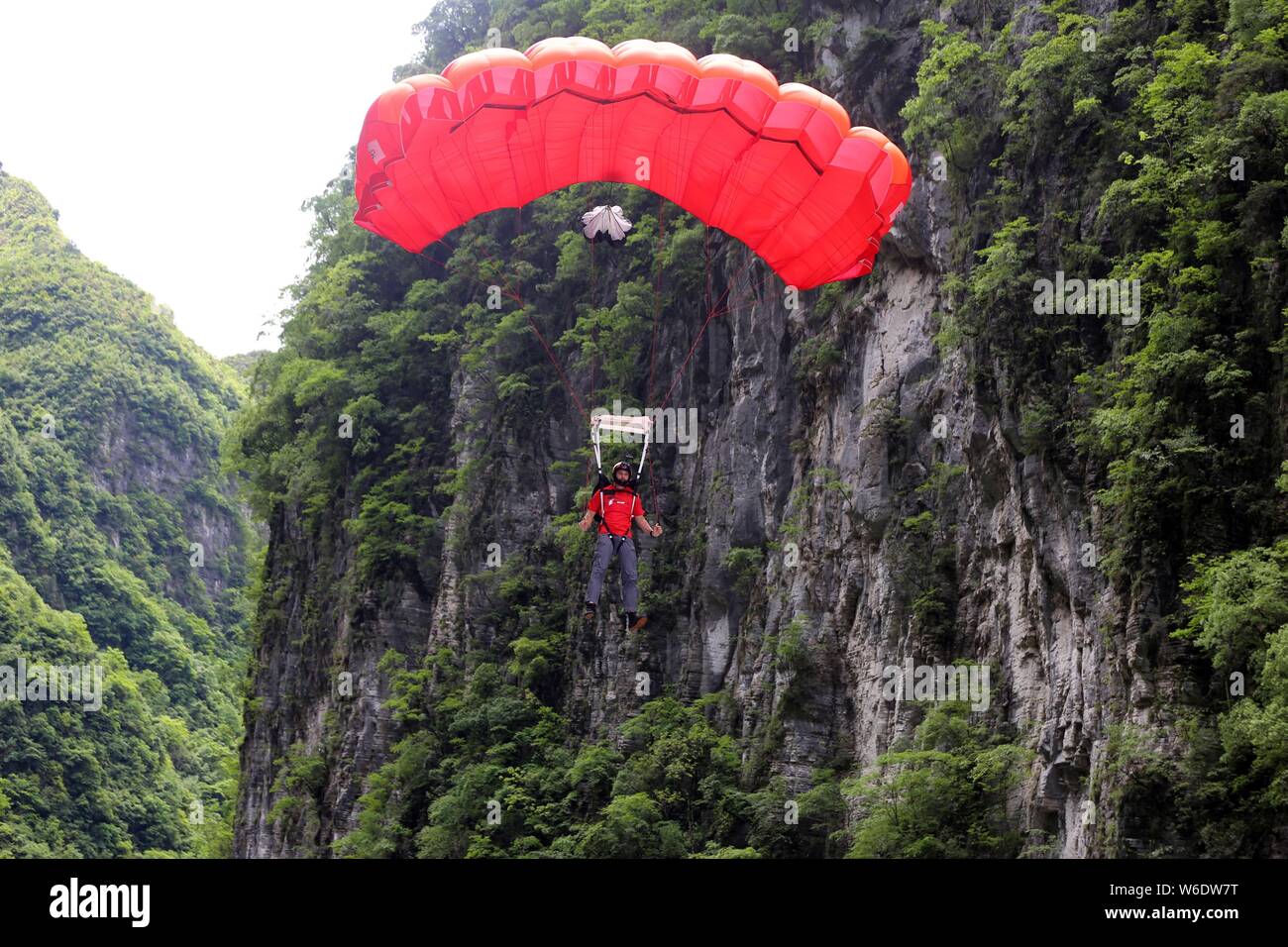 A contestant jumps off the glass cantilever bridge on the cliff during ...