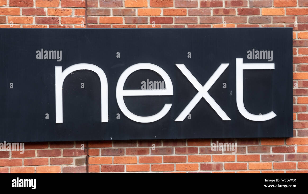 A Next Shop sign on a brick wall Stock Photo - Alamy