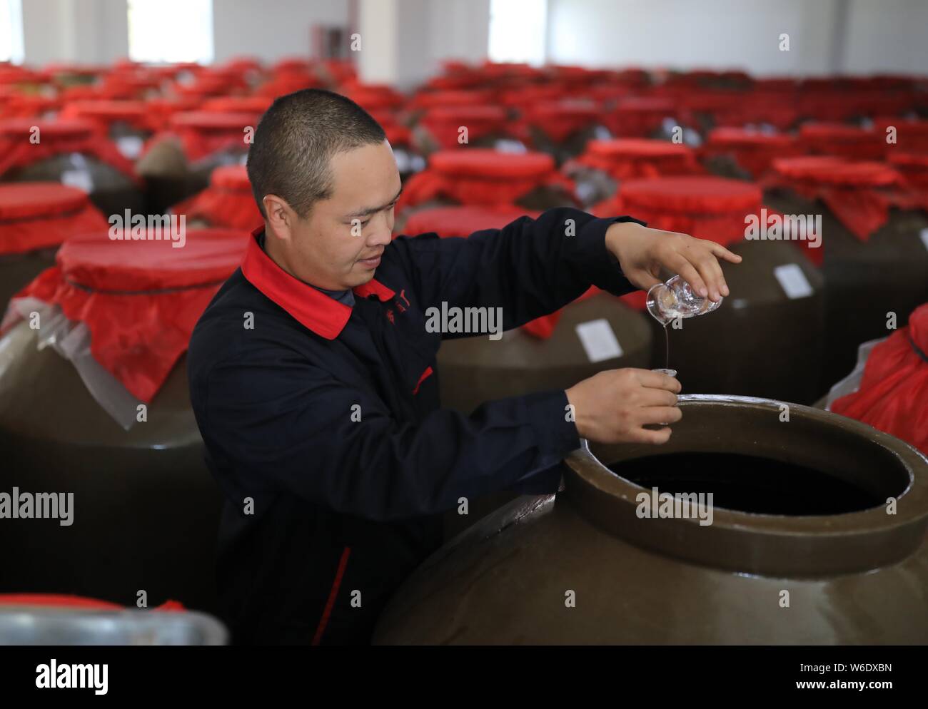 A Chinese worker checks Bijie Daqu, a sub-brand Chinese liquor derived ...