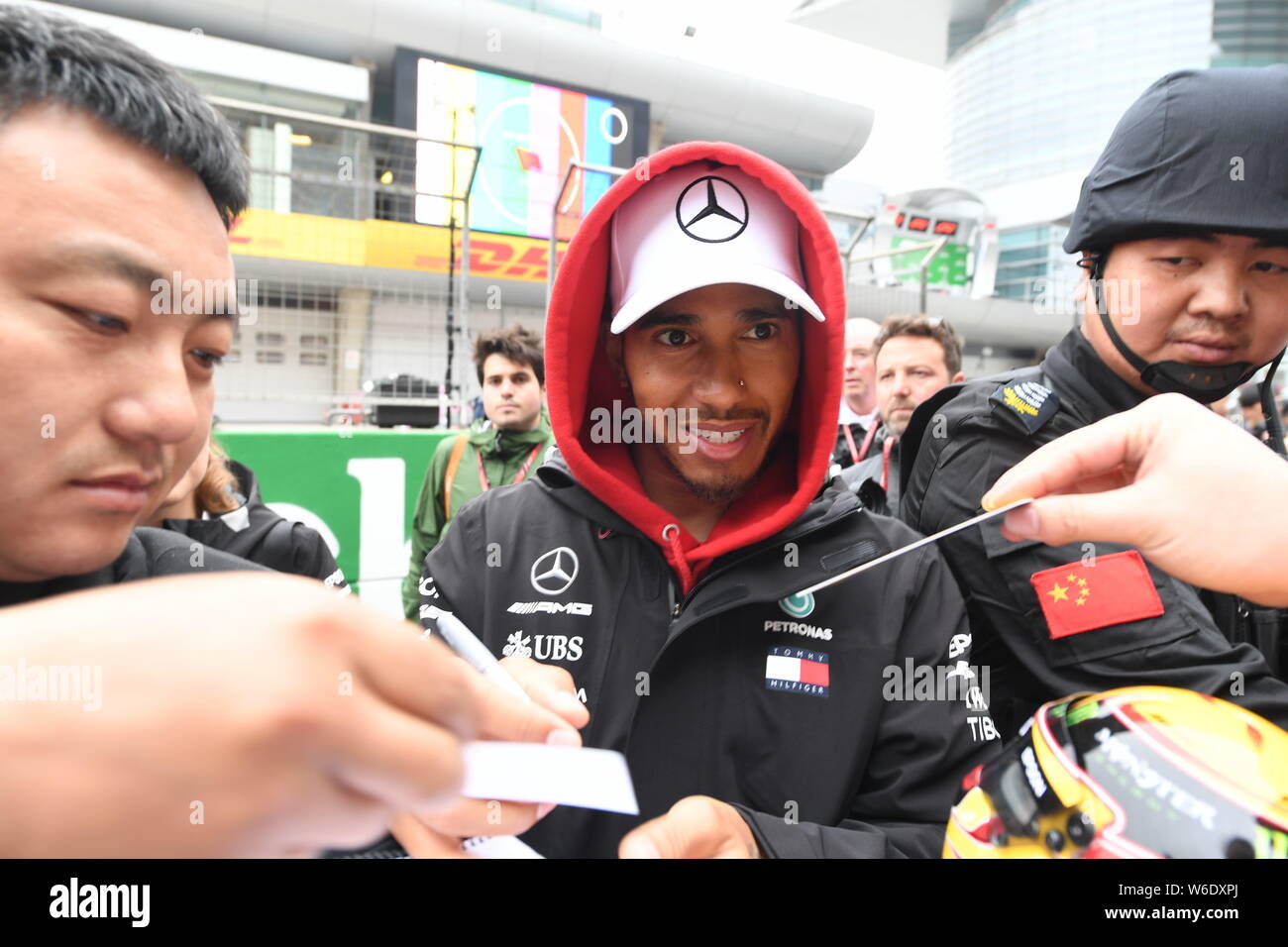 British F1 driver Lewis Hamilton of Mercedes signs autographs for fans ...