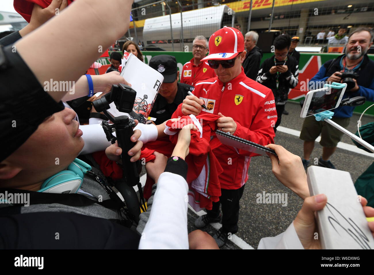 Finnish F1 driver Kimi Raikkonen of Ferrari signs autographs for fans ...