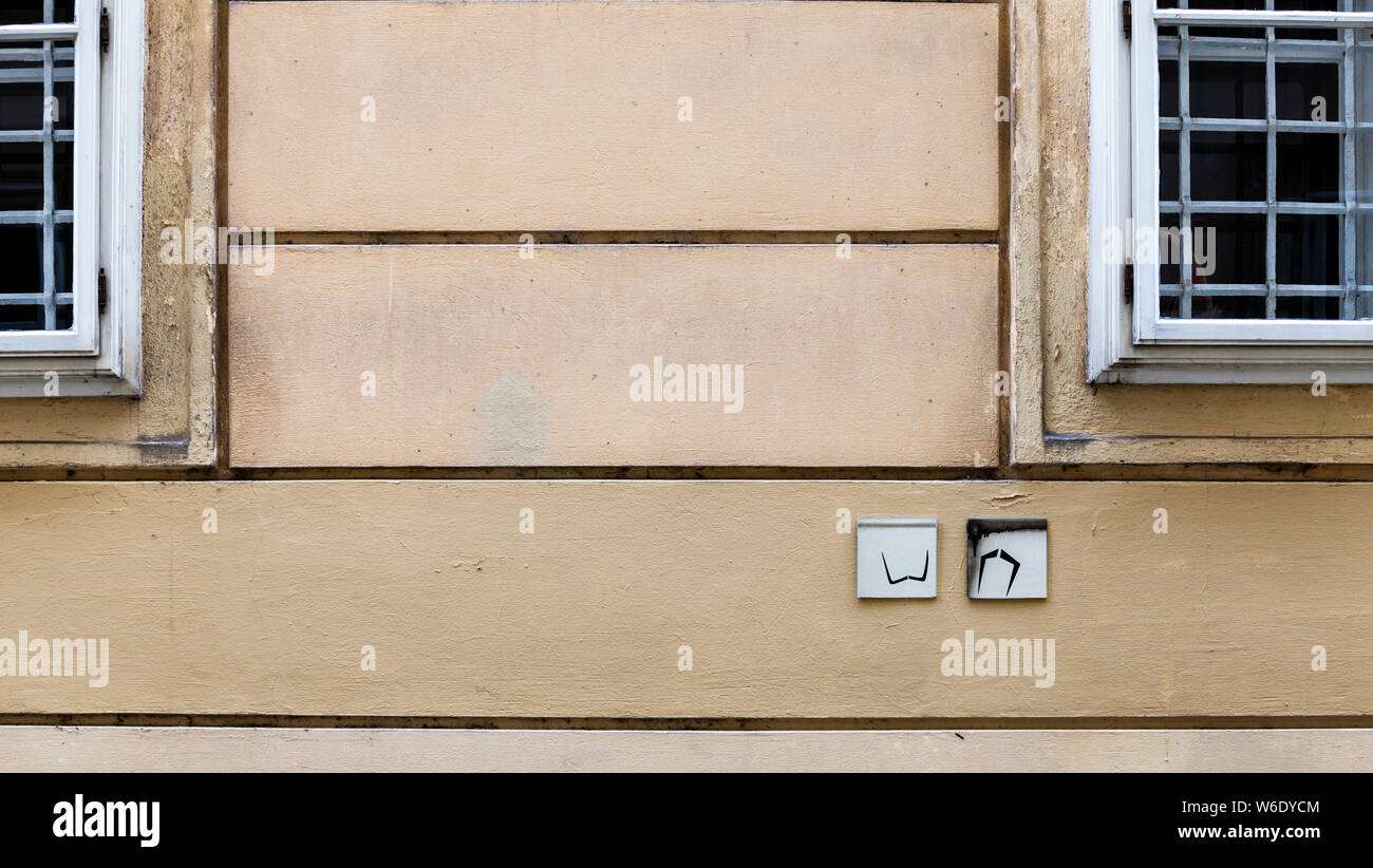 Barred windows and qudratic signs with strange symbols on a wall in ...
