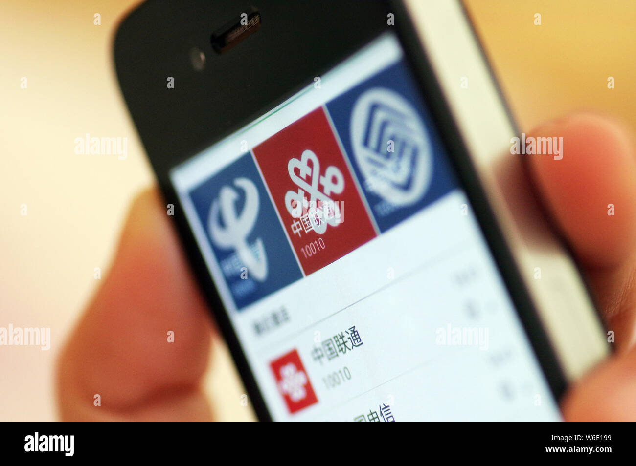--FILE--A Chinese mobile phone user shows logos of China Telecom, China ...