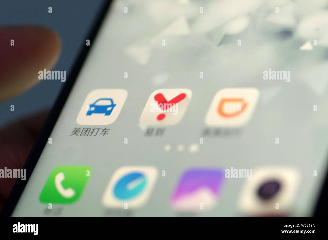 --FILE--A mobile phone user shows the icon of mobile app Meituan Dache ...