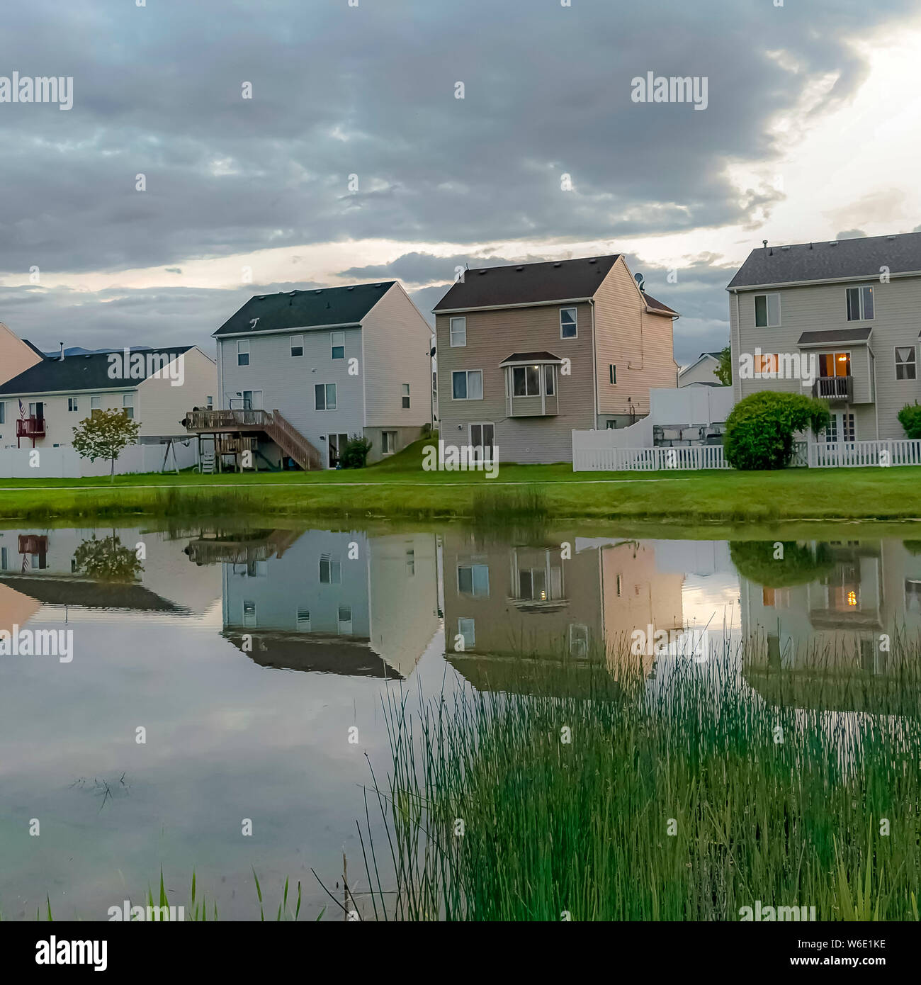 Square Family homes and bright cloudy sky reflected on the shiny ...